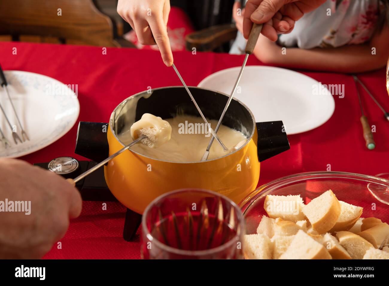 Bread being dipped in Swiss Cheese for fondue dinner Stock Photo - Alamy