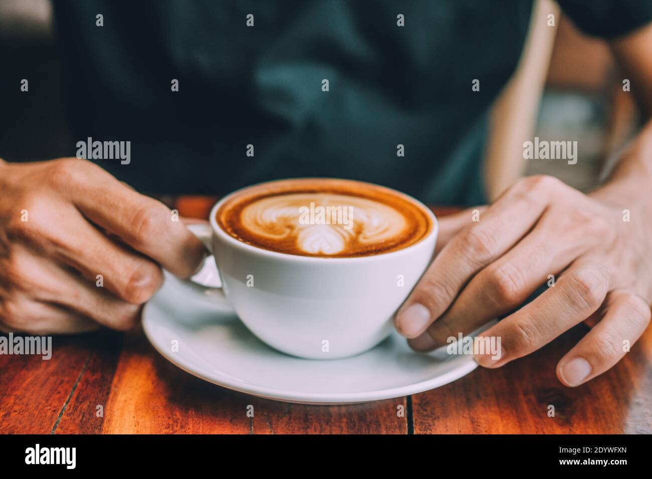 Hand holding a cup of coffee latte And Drinking Coffee Stock Photo - Alamy