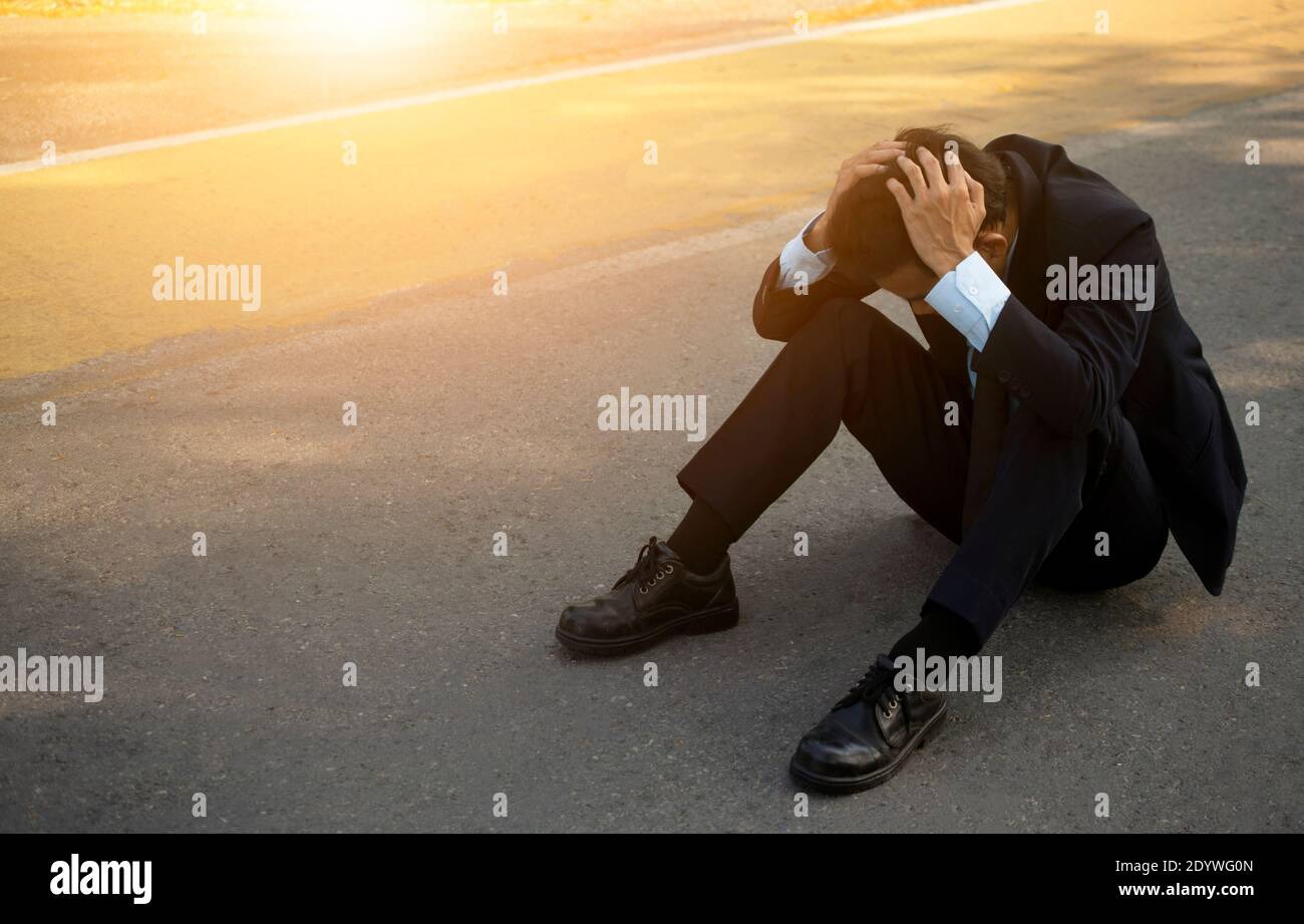 Man sitting on the road because of disappointment. The business failed ...