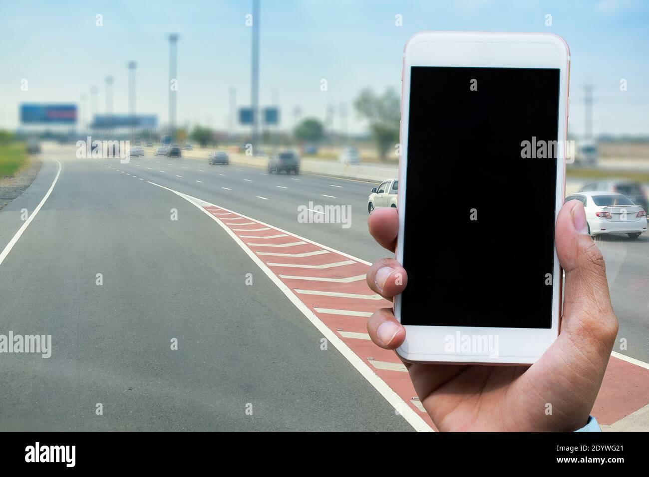 Hand holding mobile smart phone and Road background Stock Photo - Alamy