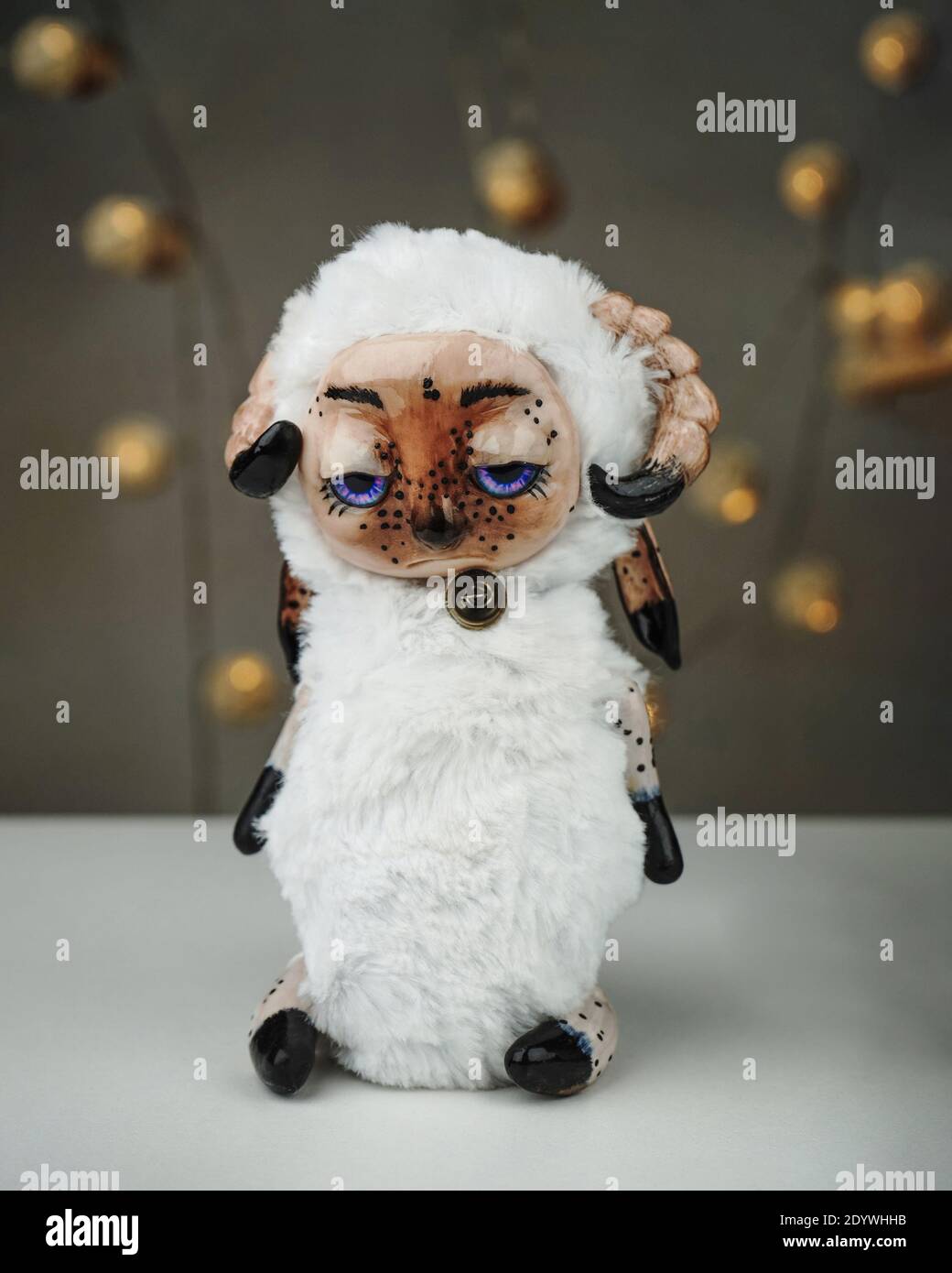 Handmade toy sad Sheep made of polymer clay on a blurred background ...