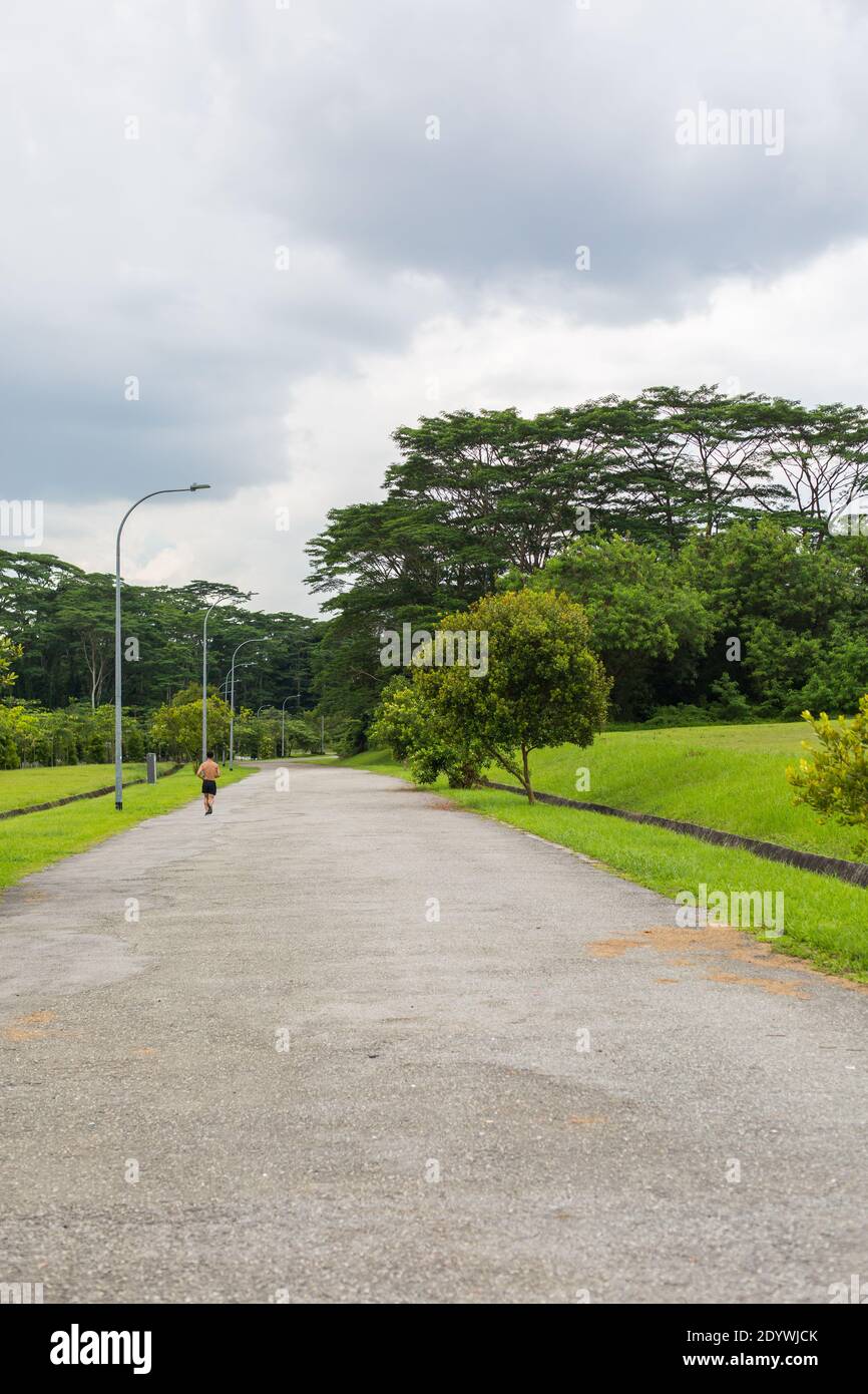 Vertical scene - back view of a man bare body jogging on a wide ...