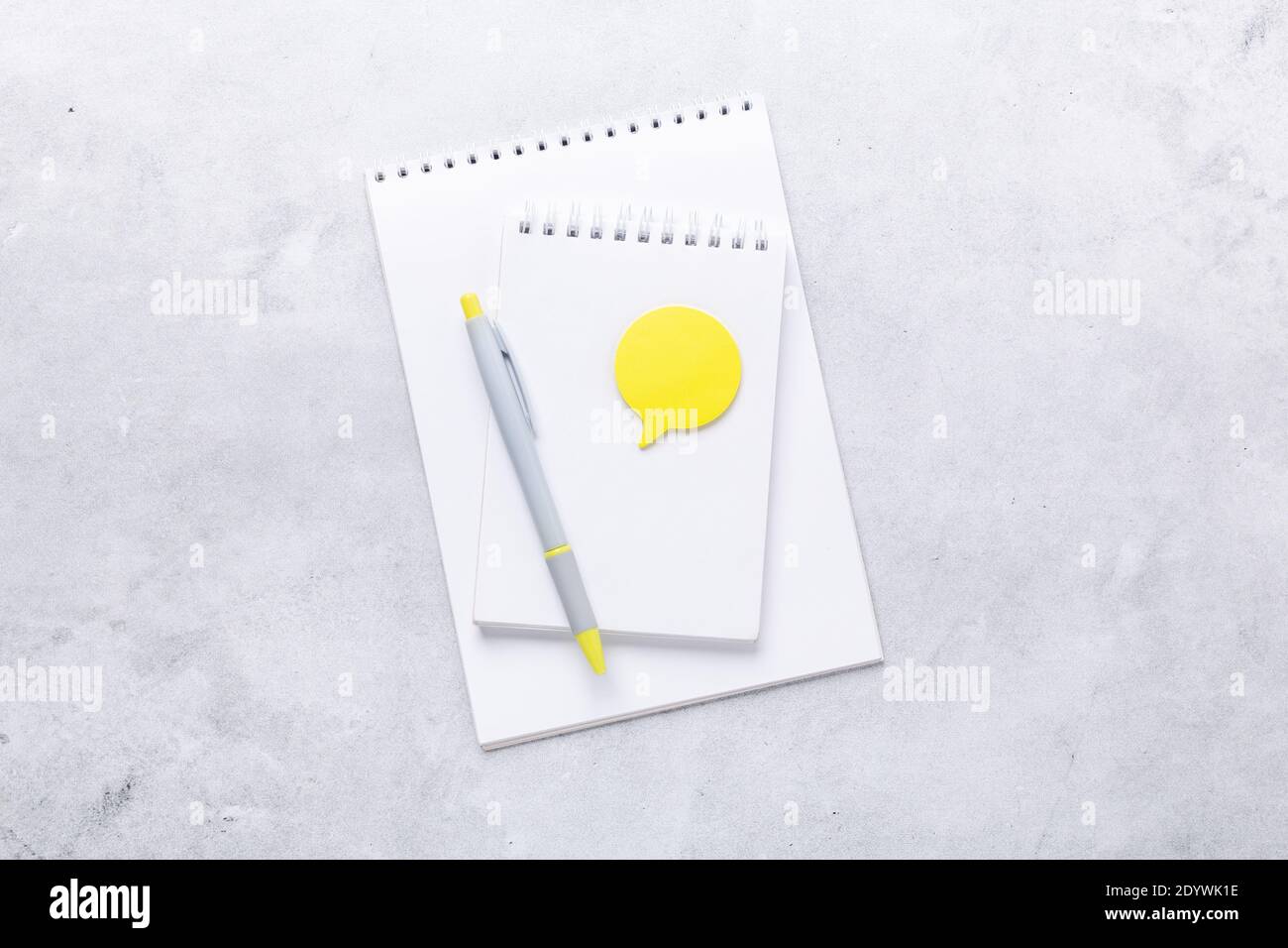 Office workplace. Notepad with pen and yellow sticker on gray stone ...