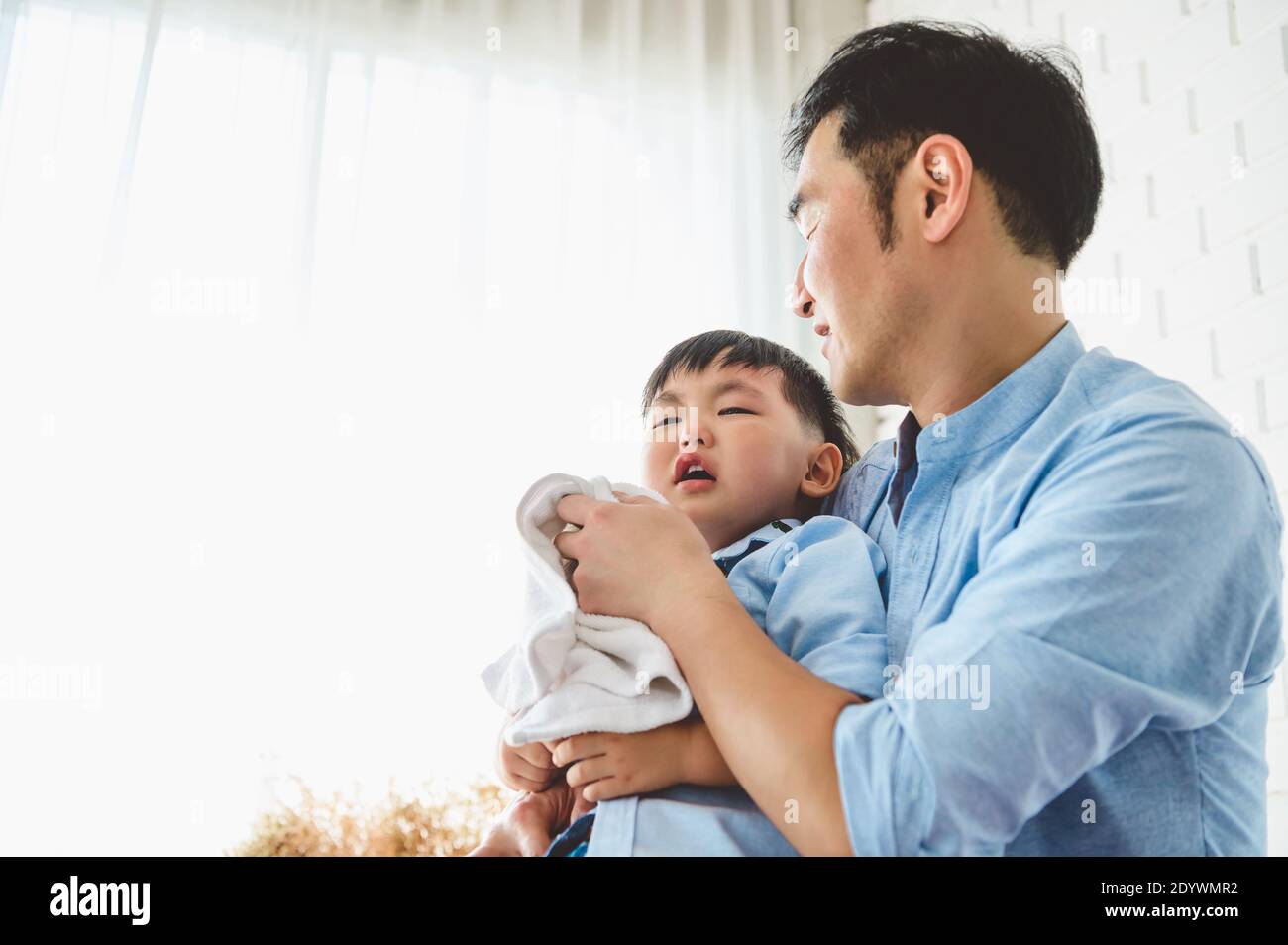 Asian Japanese father consoling his crying son and wiping tears in ...