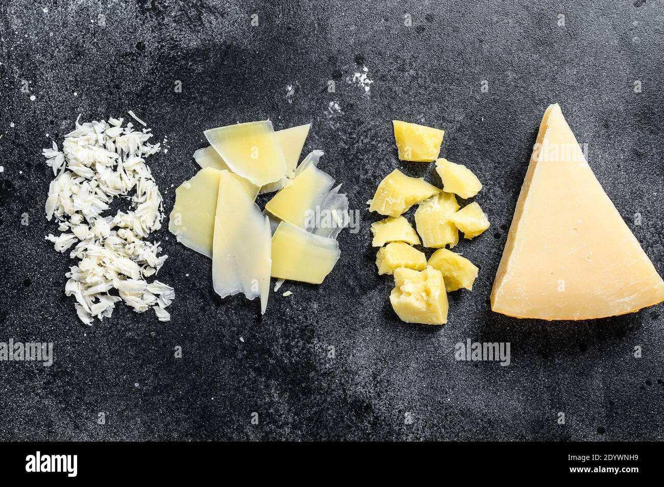 Italian hard Parmesan cheese slice, cut, grated. Black background. Top ...