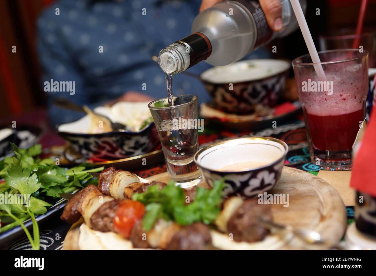 Man pouring vodka into glass at restaurant Stock Photo - Alamy