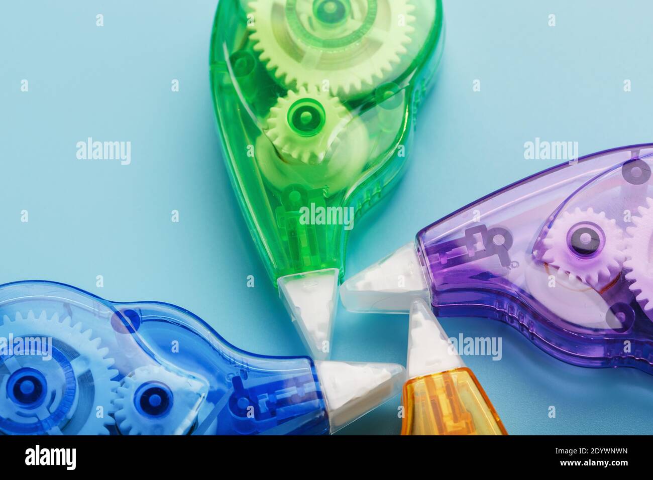 Multi-colored Stationery correction tapes on a blue background. Close ...