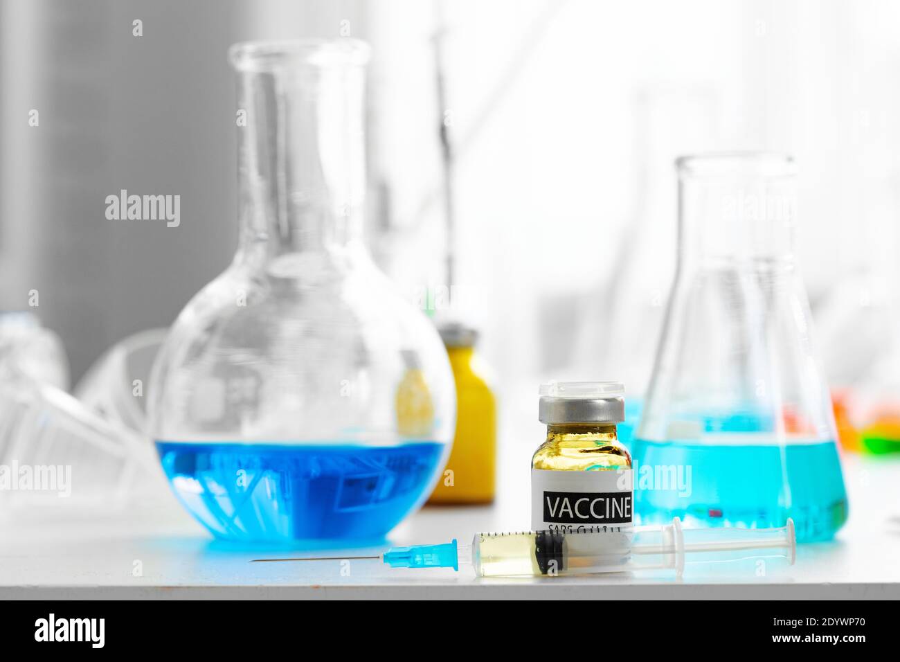 Vaccine in vial for injection on table against background of laboratory ...