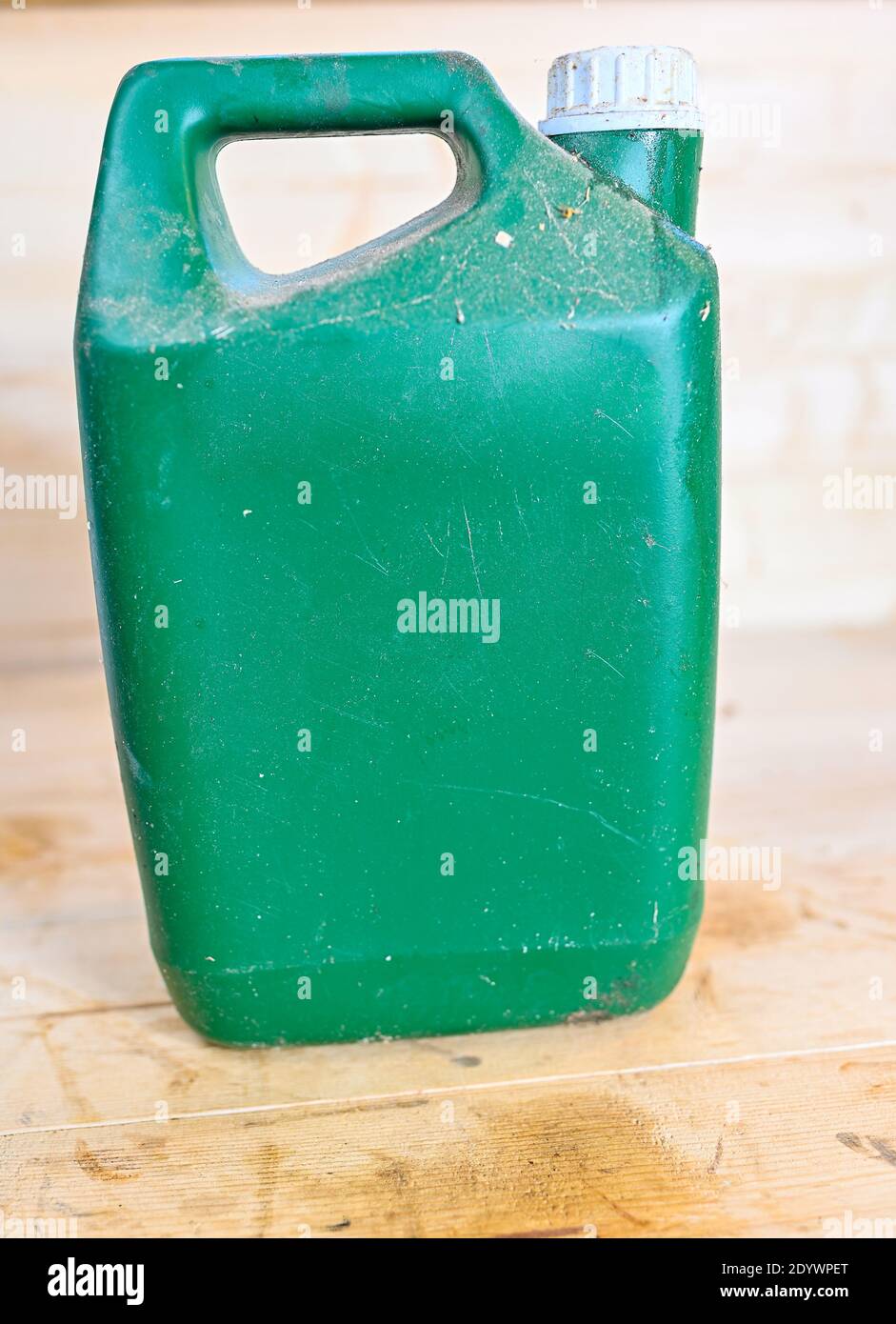 dirty old plastic gas can on wooden bench Stock Photo - Alamy