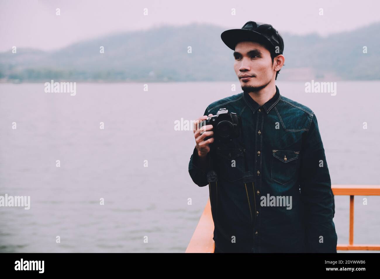 One man Travel around the world with one camera,Man holding camera on ...