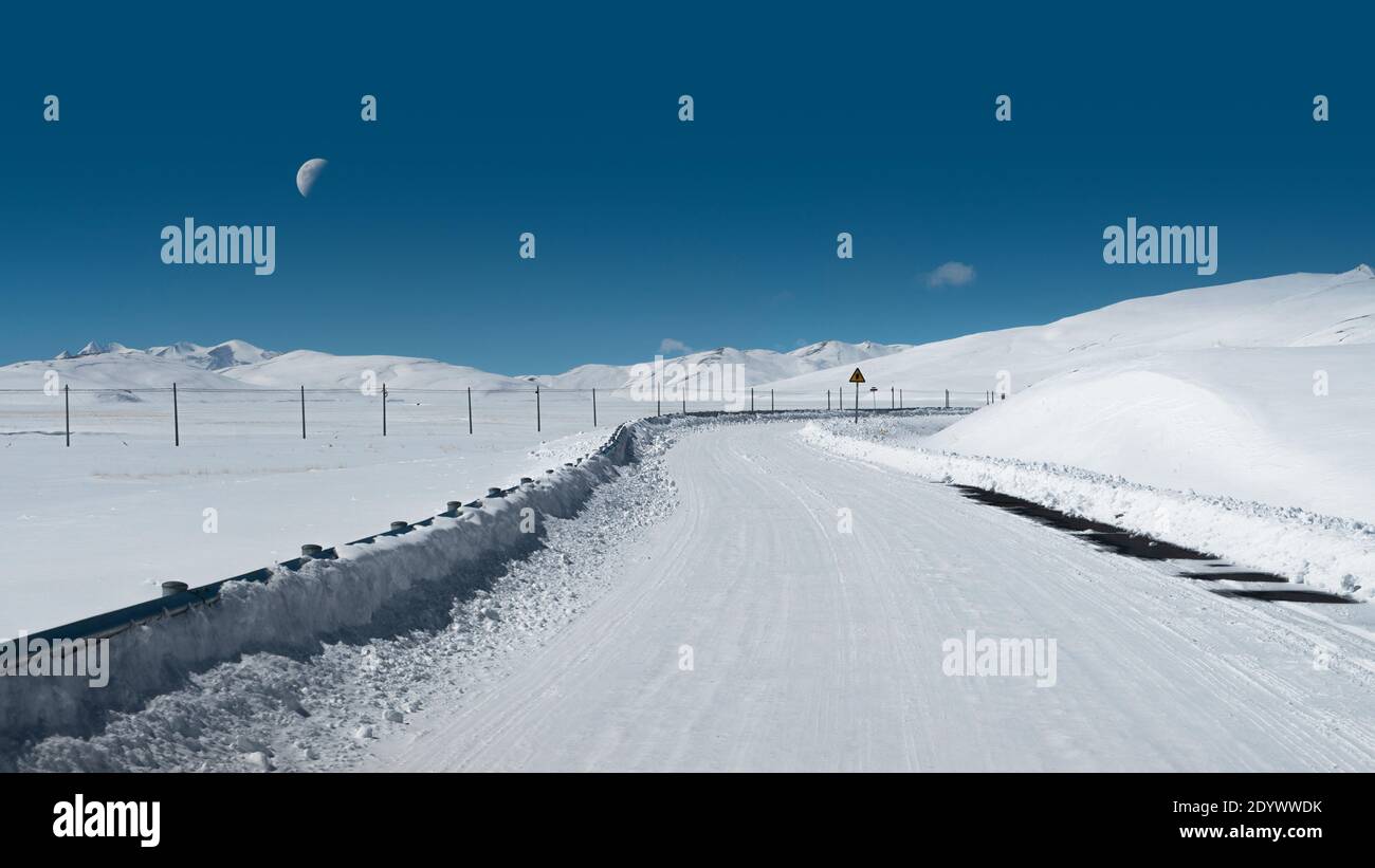 Turn Road with snow and moon in blue sky in Tibet,West of China Stock ...