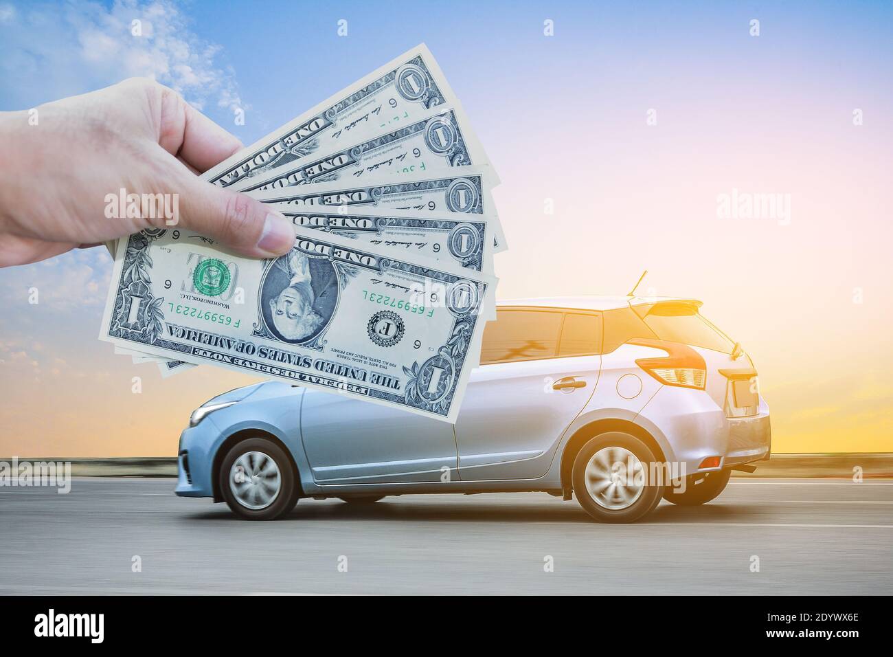 Hand holding money dollar and car driving on road background Stock ...