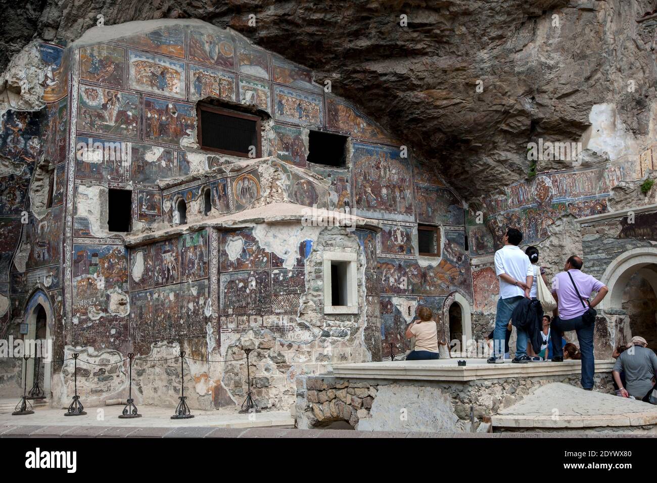 Tourists admire the Rock Church frescoes at Sumela Monastery. It is a ...