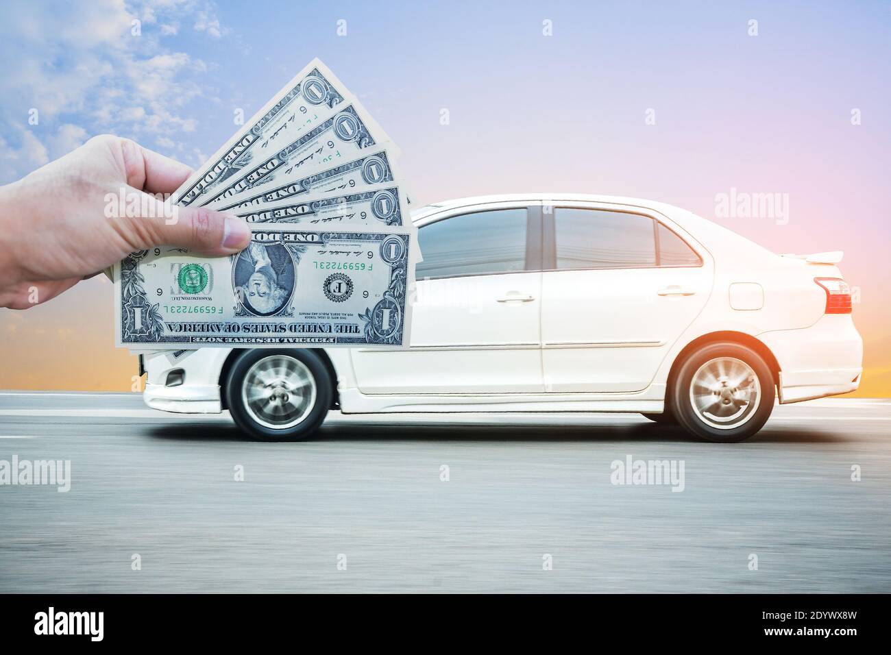 Hand holding money dollar and car driving on road background Stock ...
