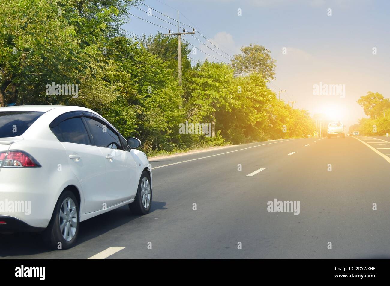 Blurry car driving on road against sunset Stock Photo - Alamy