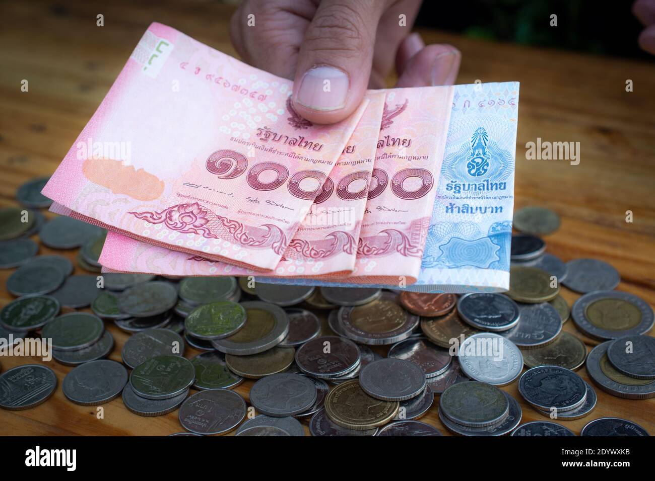 Thai bank note and Coins on wood table Stock Photo - Alamy
