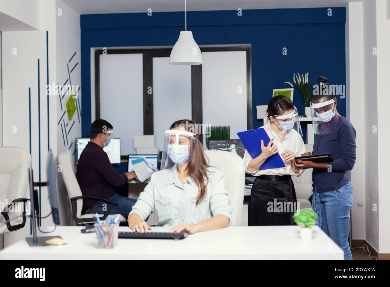 Employees following safety precaution during covid19 wearing face mask ...