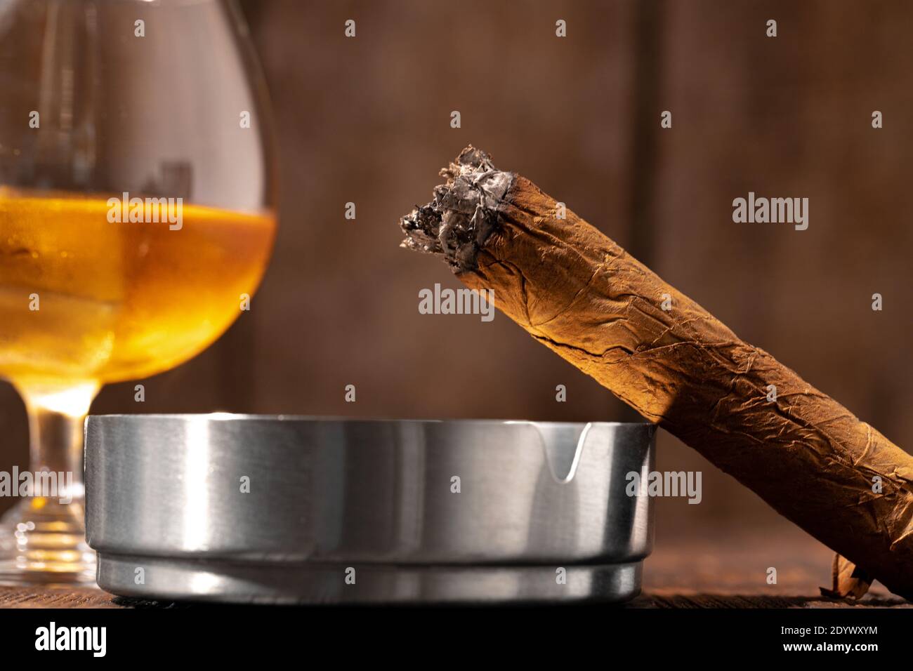 Glass of whisky and lighted cigar in an ash tray Stock Photo - Alamy