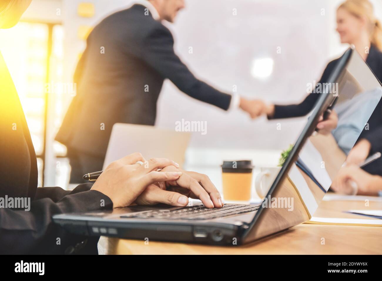 Business people use computer and hands shake business partnership ...