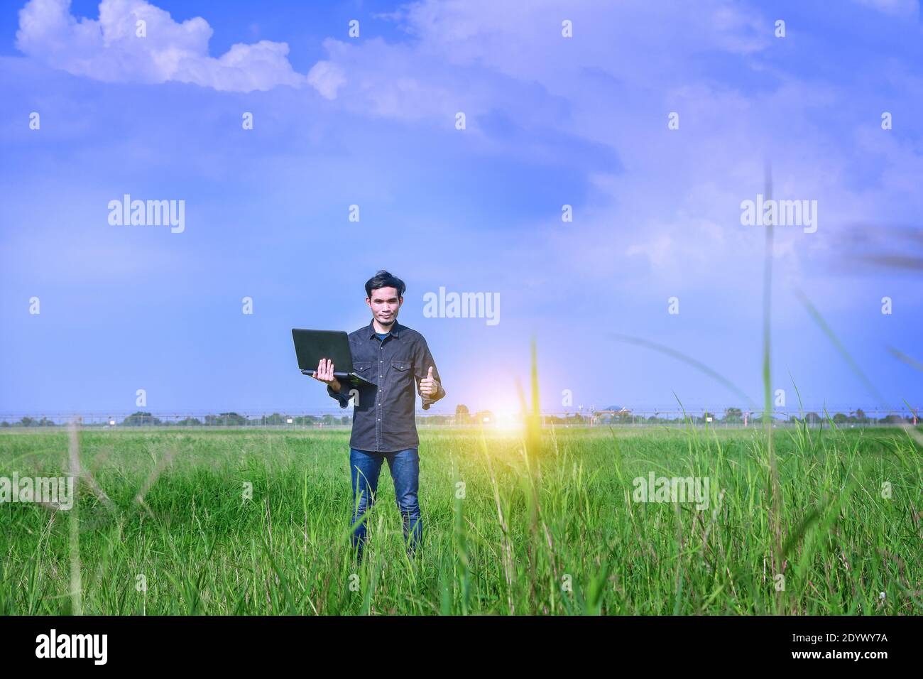 Man holding computer notebook standing green field sky could background ...
