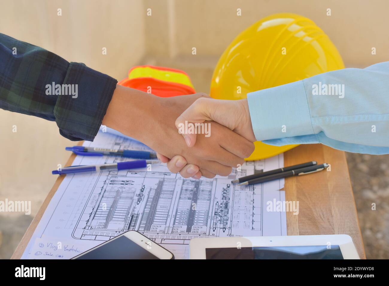 Close up People Shake hand at blueprint construction site background ...