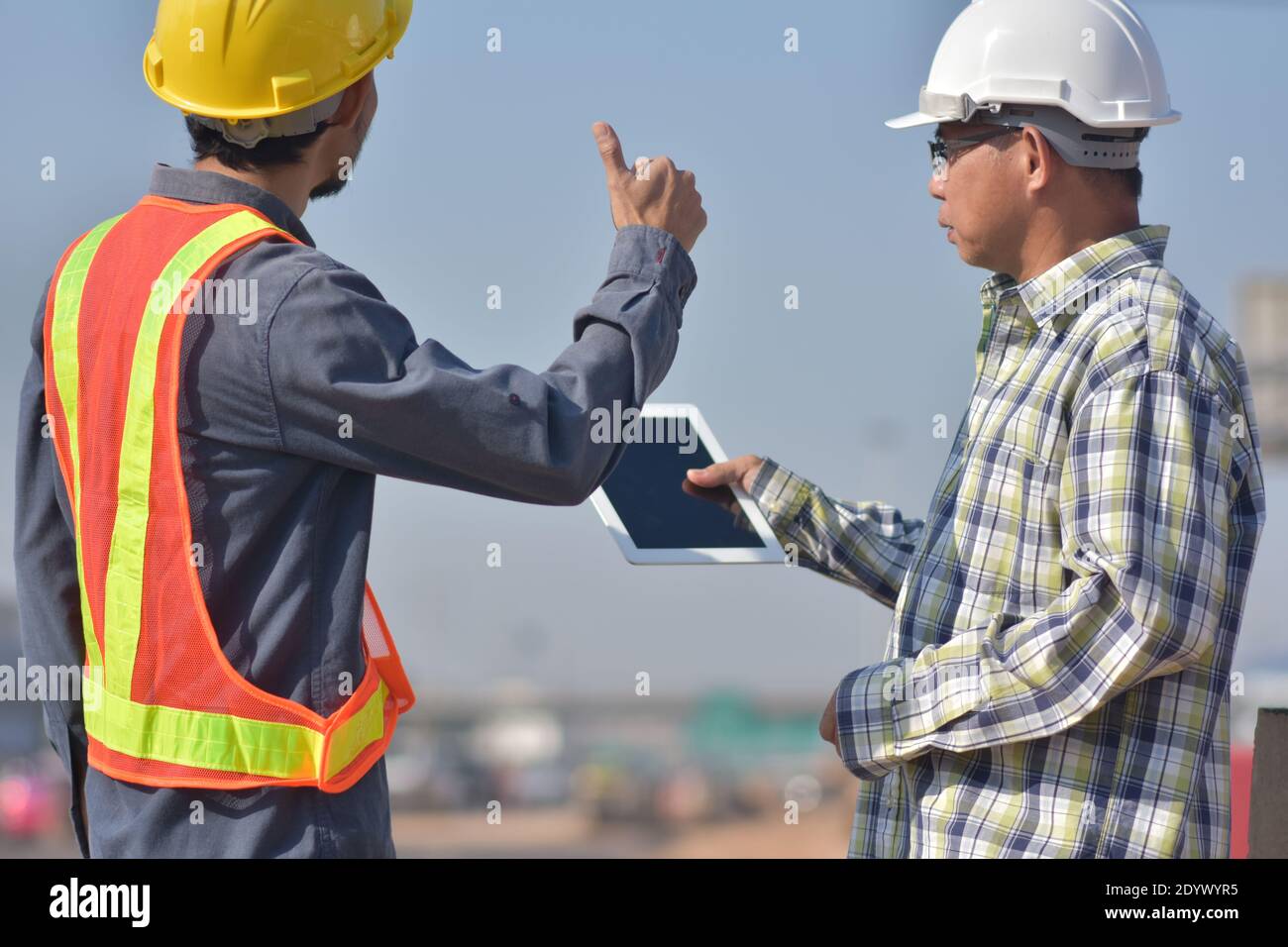 Engineering holding tablet work on road construction Stock Photo - Alamy
