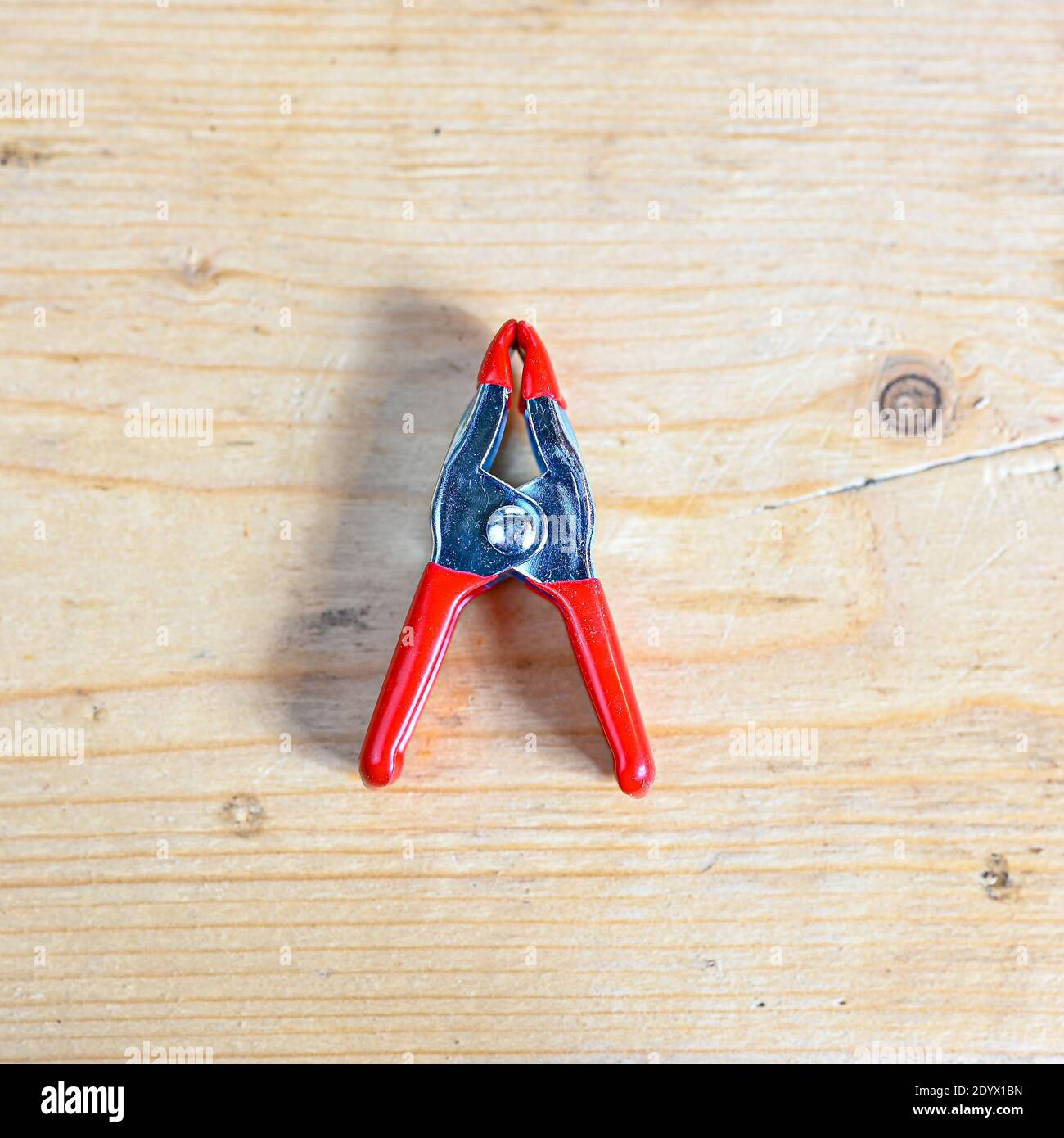 tiny little clamp lying on wooden bench Stock Photo - Alamy