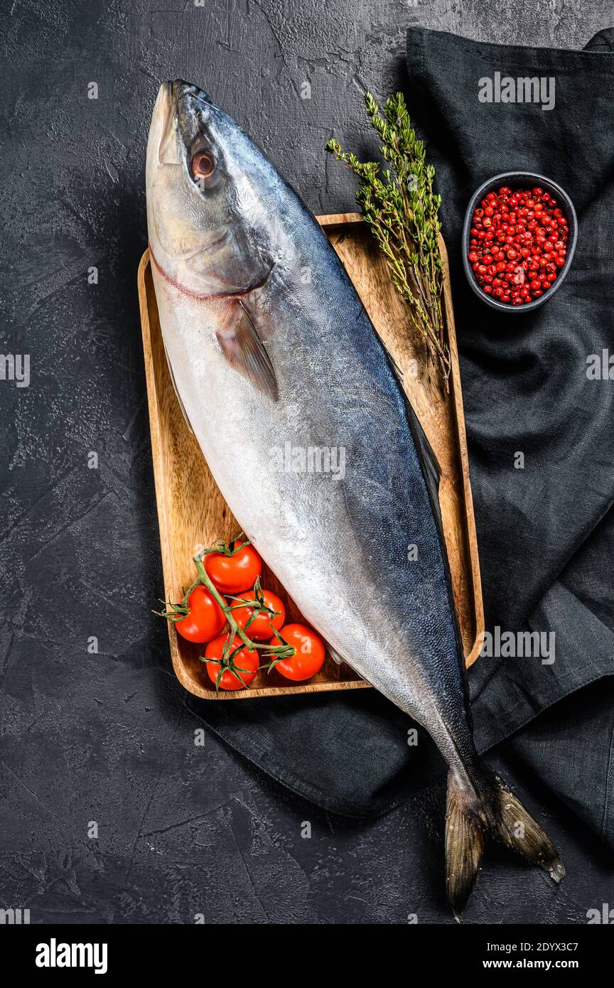 Fresh whole raw Japanese yellowtail with tomato and herbs. Fish ...