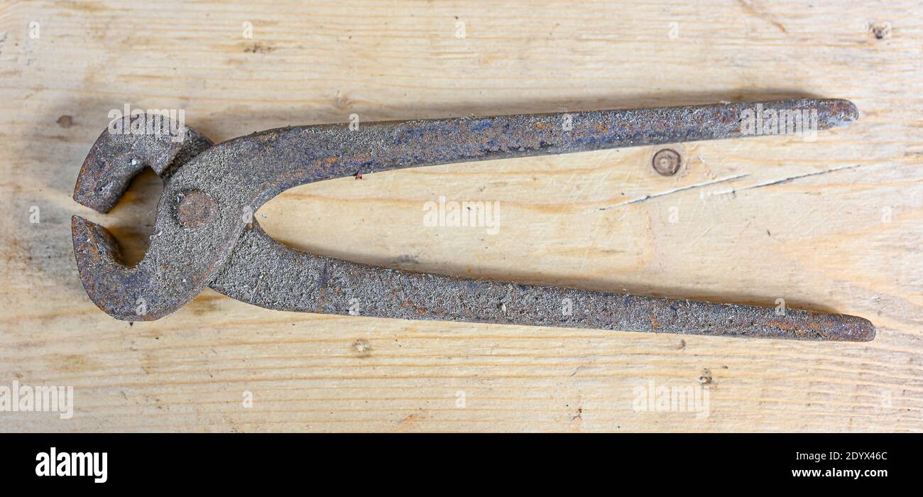 old dirty rusty vintage pincer on wooden workbench Stock Photo - Alamy