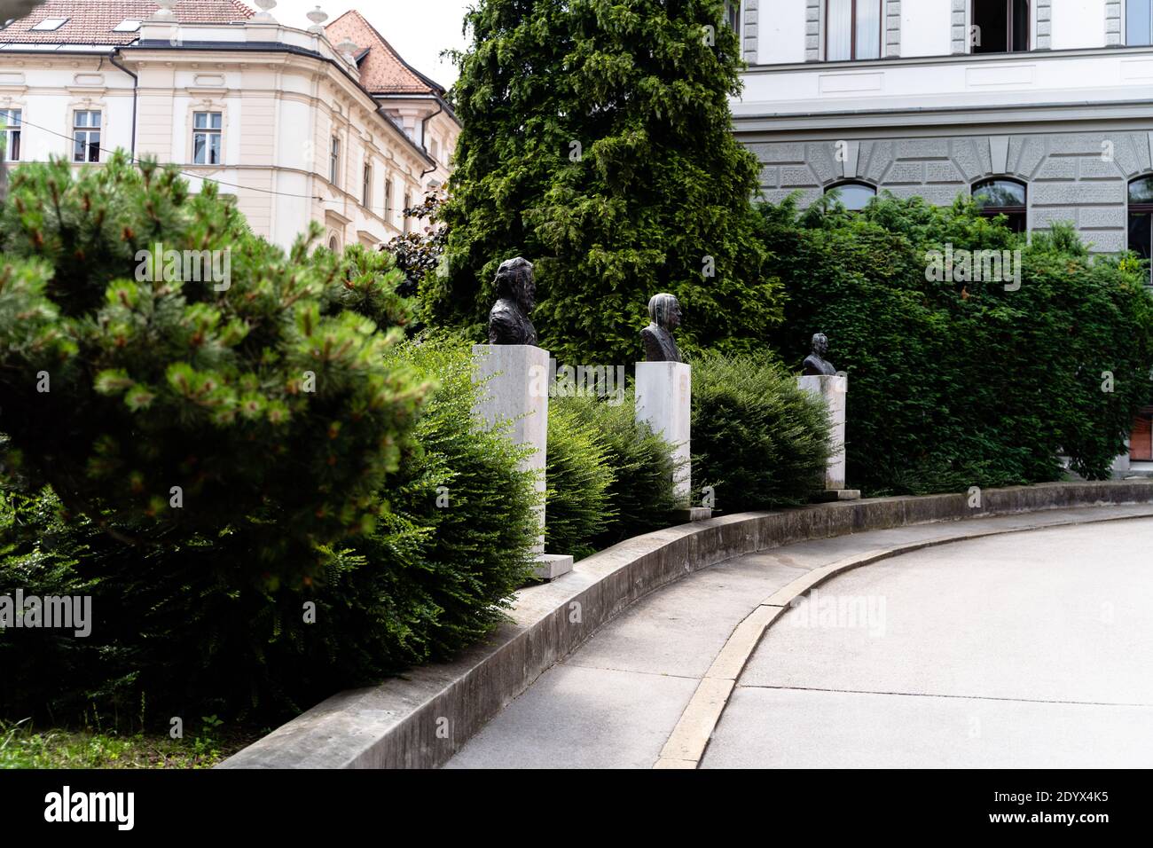 Buildings surrounded by a fresh green garden and monuments in front of ...