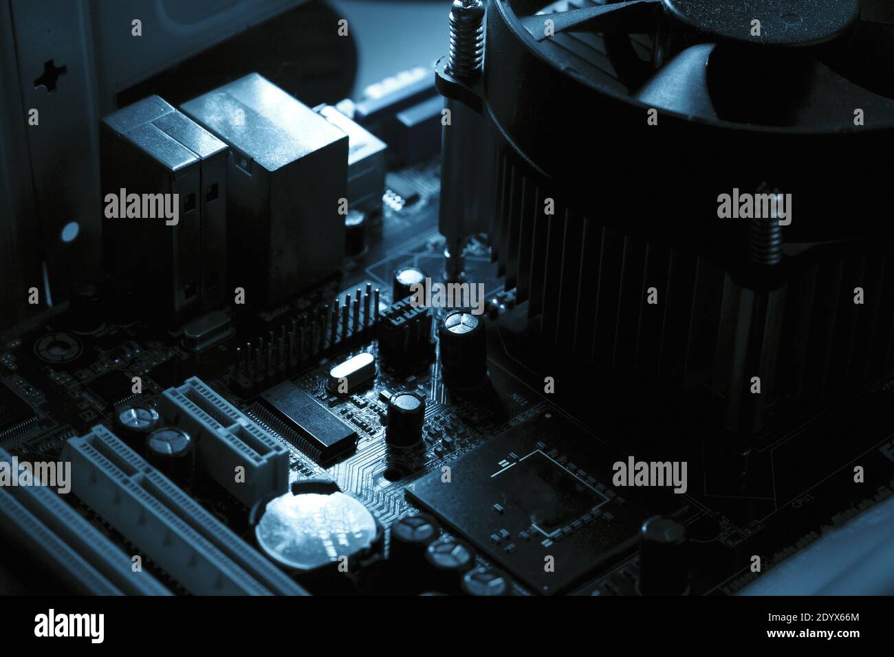 Components on PC circuit board. Chip, fan, capacitor and connectors on ...