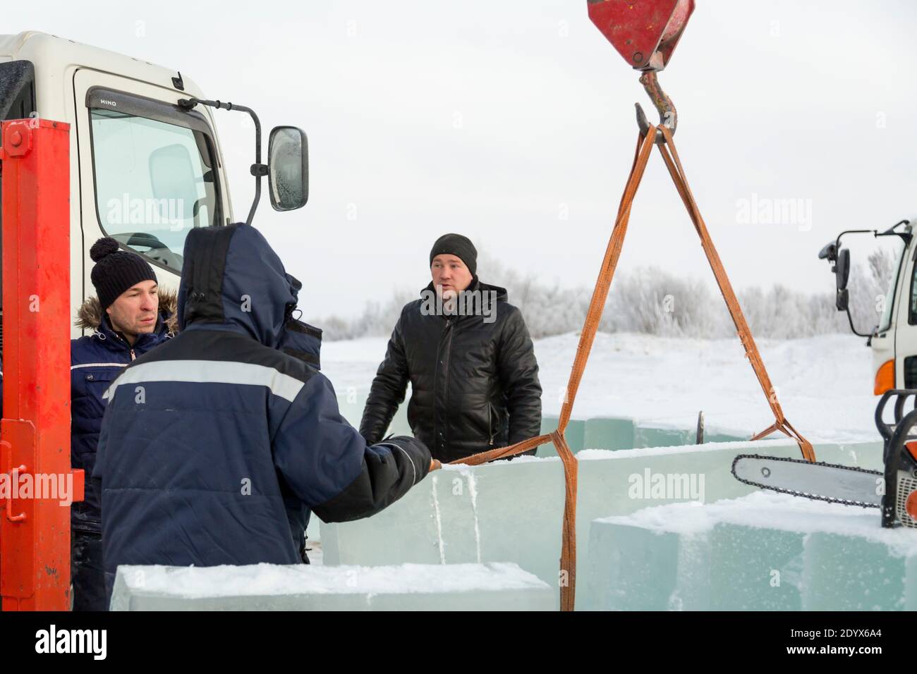 Workers prepare large ice slabs for loading to build an ice town Stock ...