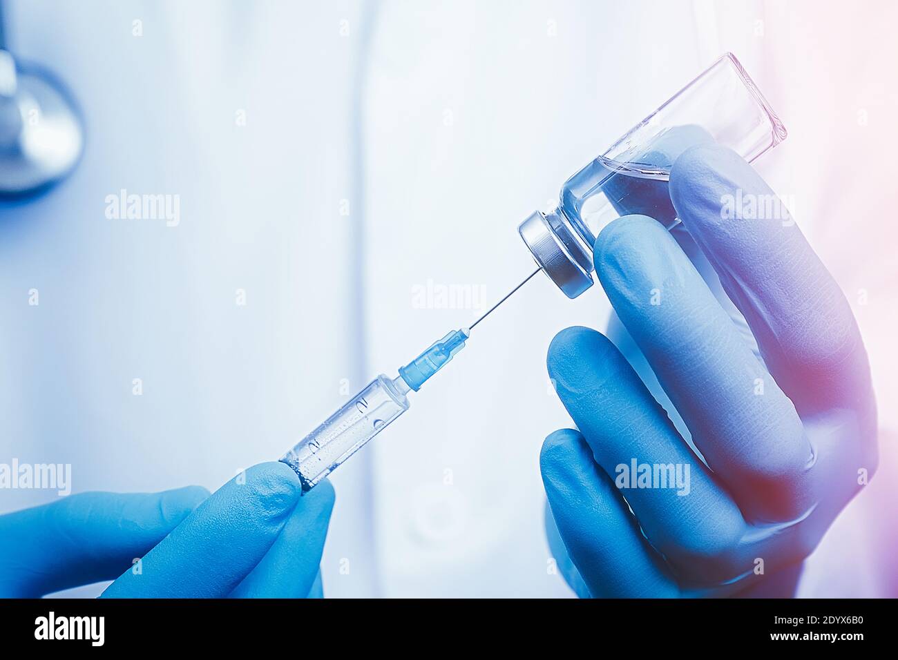 Close up doctor arm using syringe and ampoule, white robe dressed ...