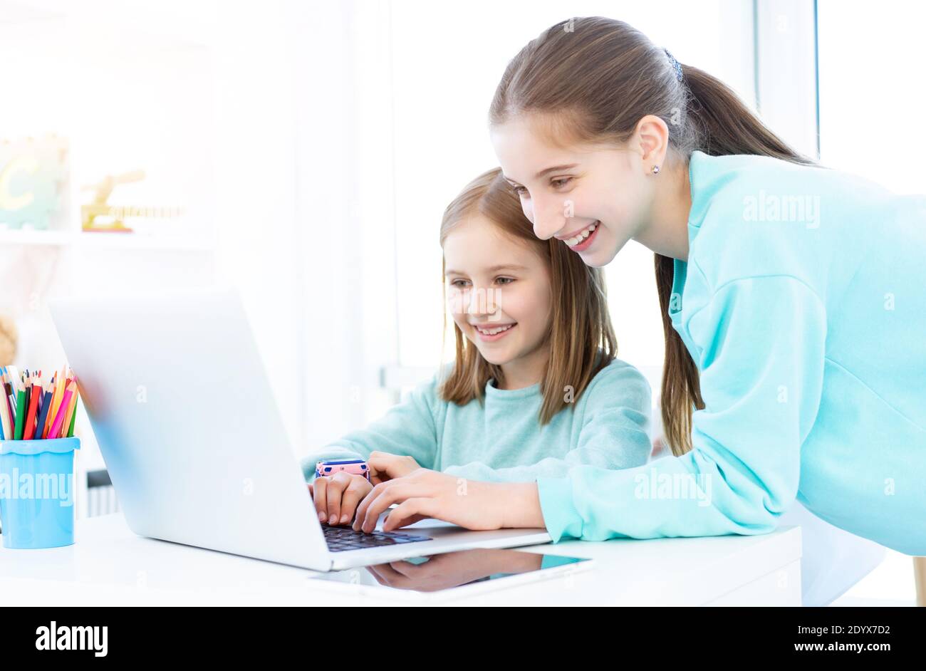 Happy girls working on computer in light room Stock Photo - Alamy