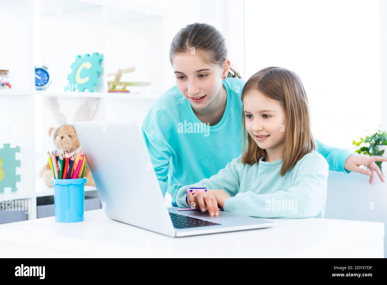 Happy girls working on computer in light room Stock Photo - Alamy