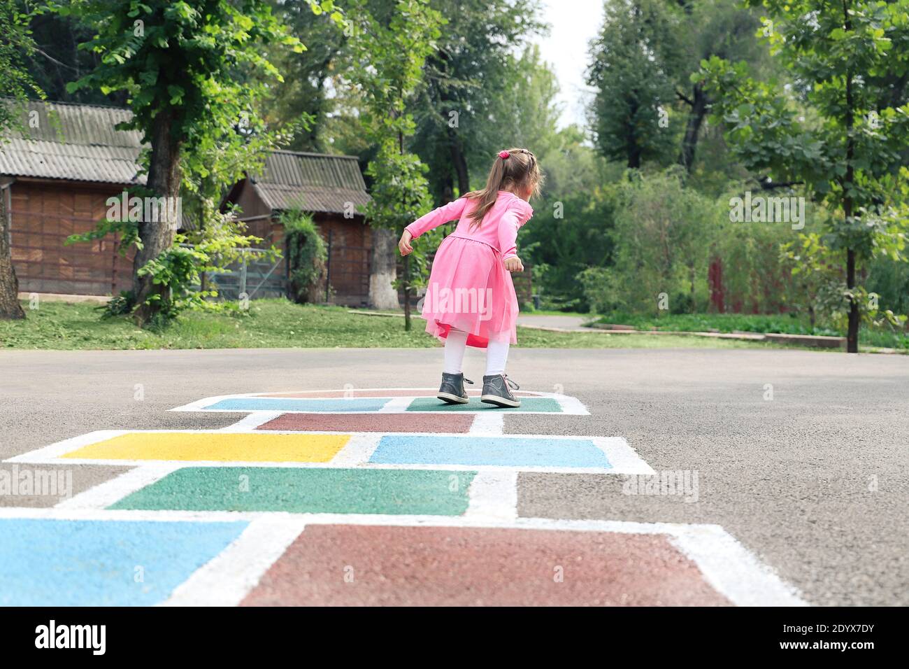 Young cute girl playing hopscotch on backyard Stock Photo - Alamy