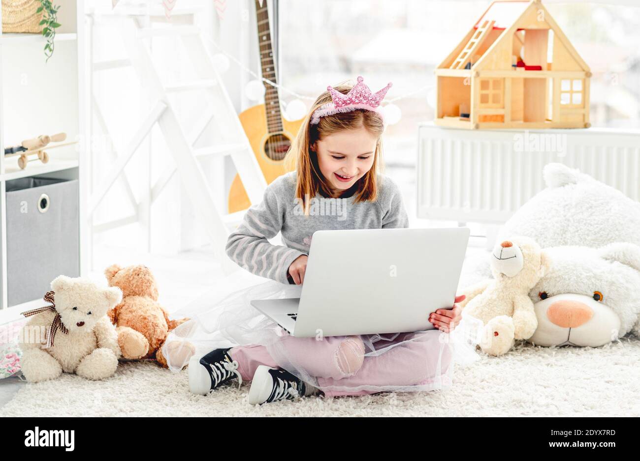 Happy little girl using computer on floor in children room Stock Photo ...