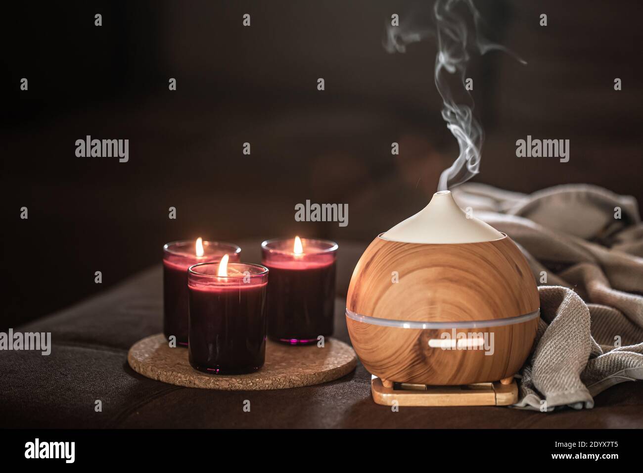 Oil diffuser on blurred background near burning candles. Aromatherapy ...