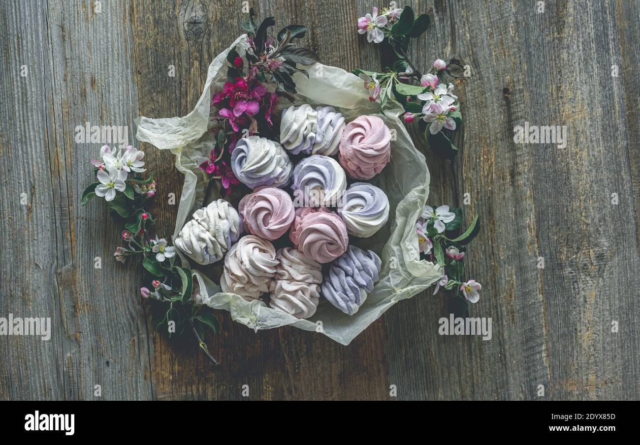 Delicious marshmallow on craft paper with spring flowers, top view ...