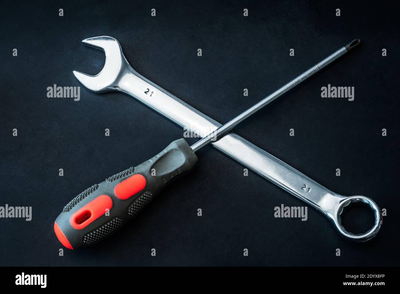 Crossed spanner and screwdriver, repair concept Stock Photo - Alamy