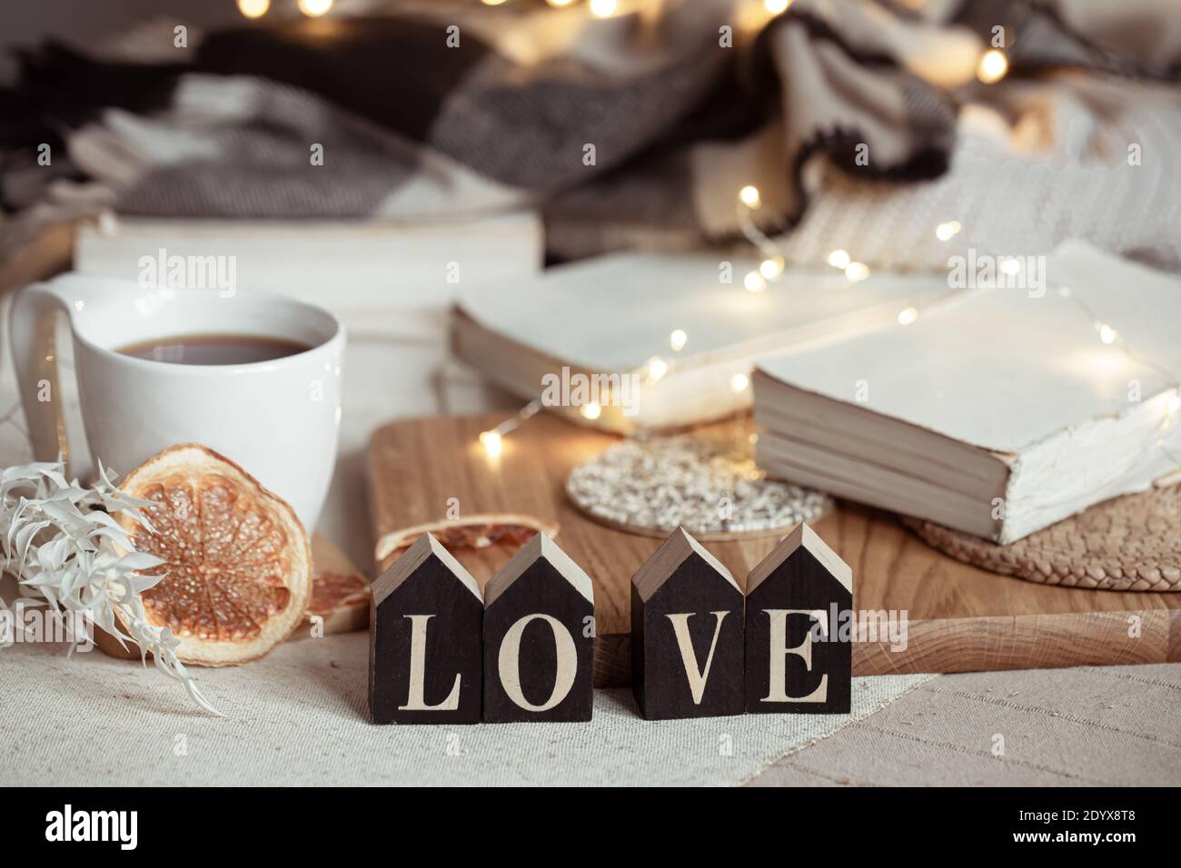Still life with the wooden word love, a cup of drink and cozy decor ...