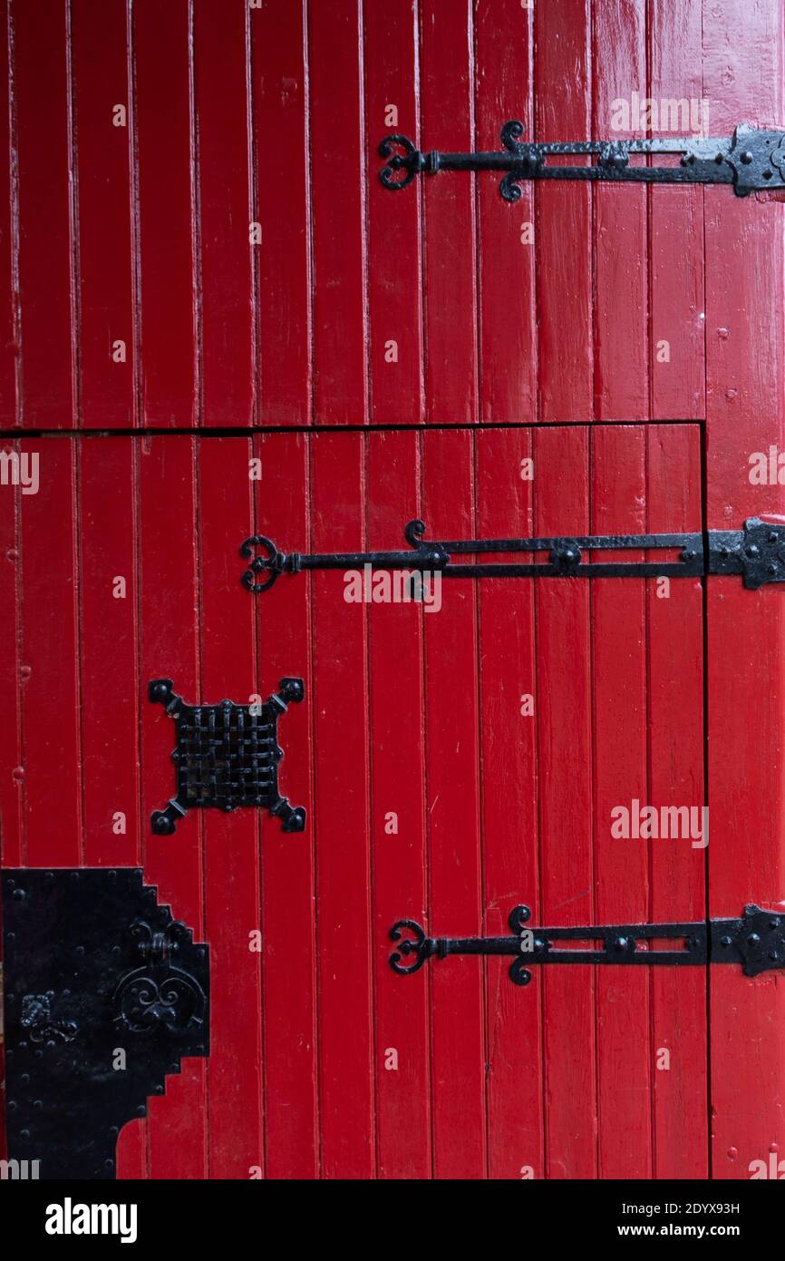 Partial view of a 16th century red castle door decorated with black ...
