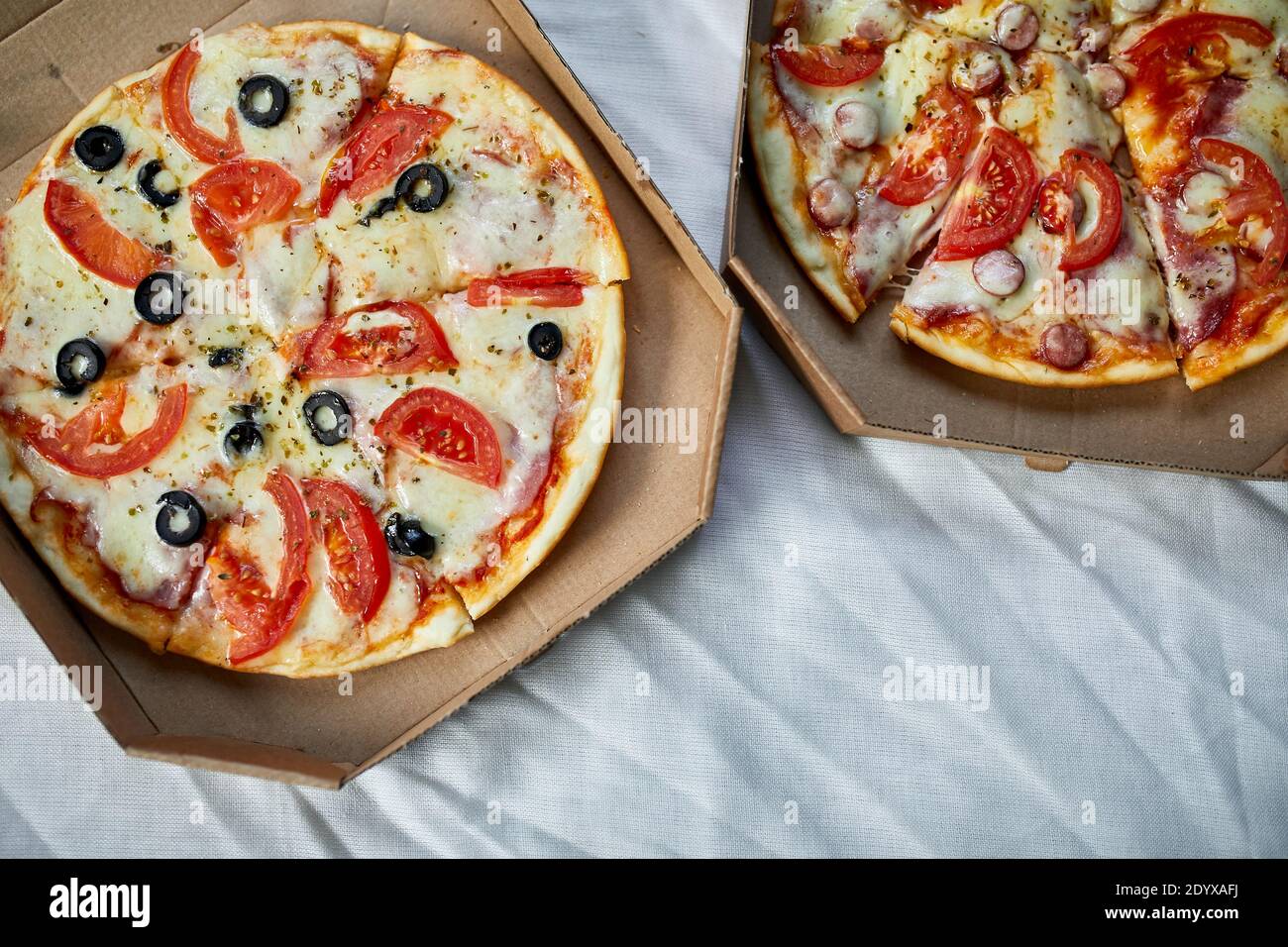 Open box with hot tasty italian sliced pizza on white background ...