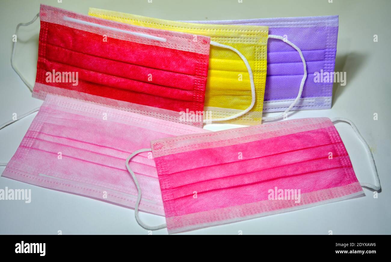 Colorful (red, yellow, purple, pink) medical masks on white ground and ...