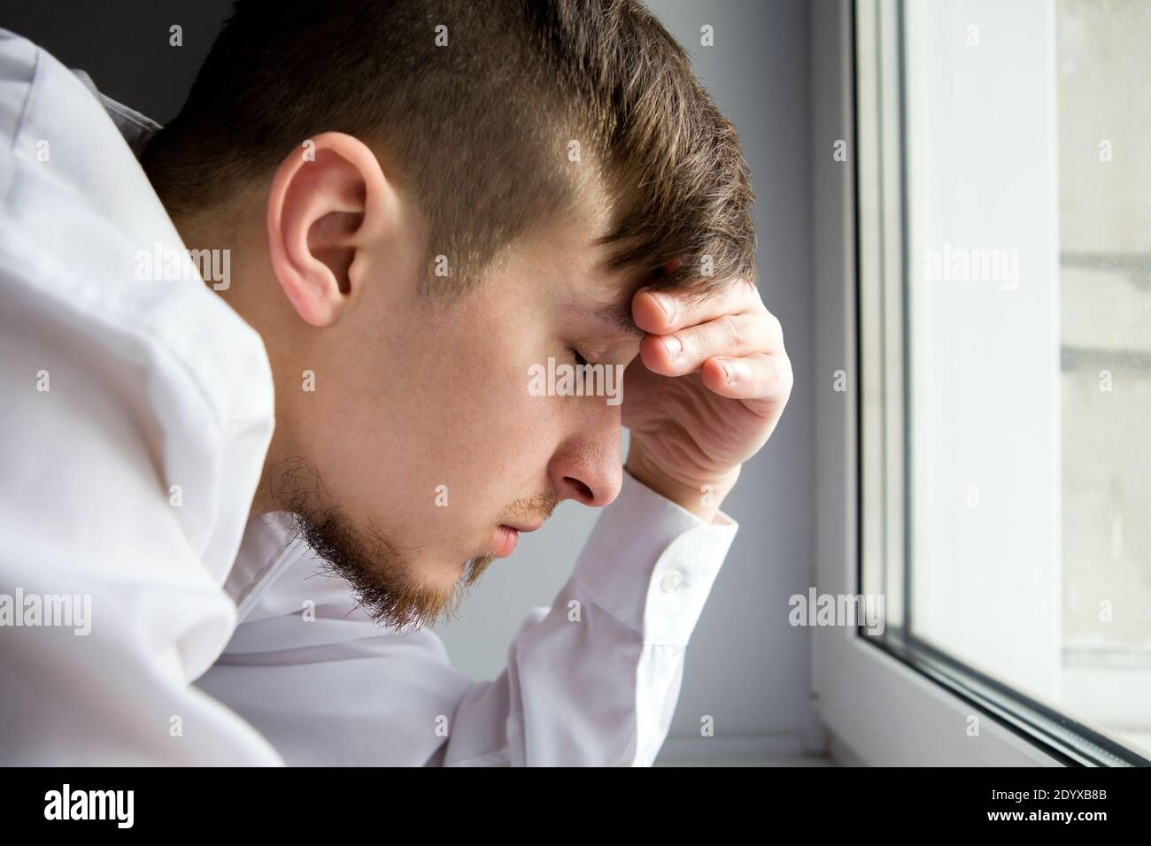 Sad Young Man by the Window in the Room Stock Photo - Alamy