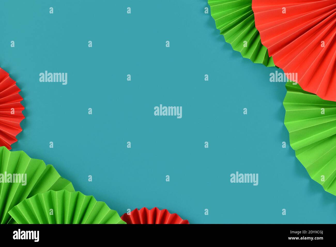 Red and green paper craft rosettes on sides of teal blue background ...
