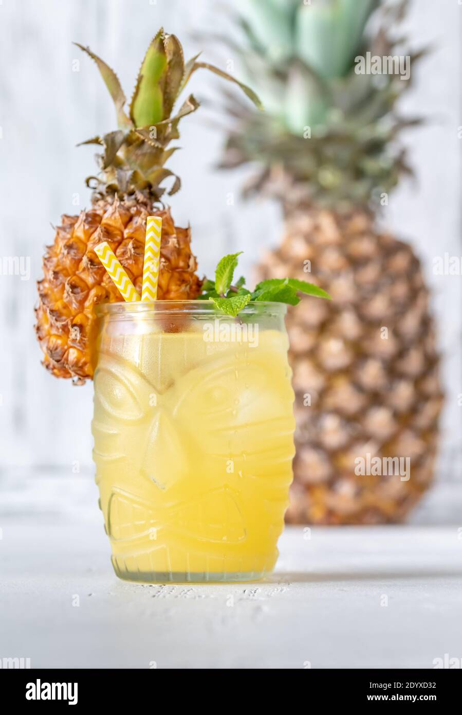 Glass of pineapple tiki style cocktail on white background Stock Photo ...