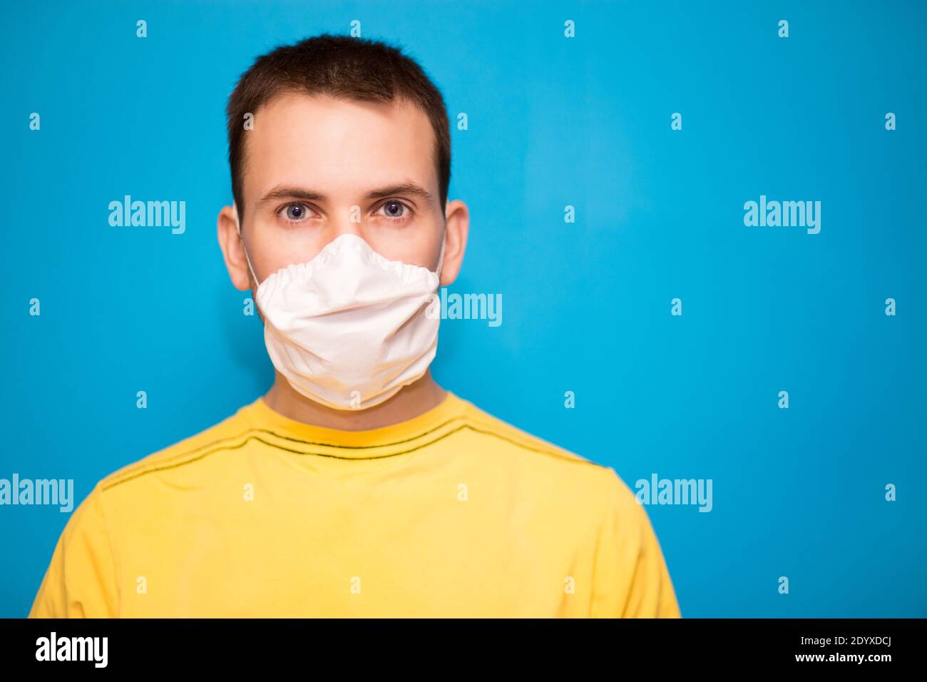 Portrait of tired young man in white medical mask on face for personal ...