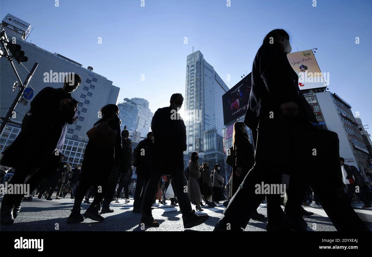 People wearing face masks walk in Tokyo's Shibuya area on Dec. 28, 2020 ...