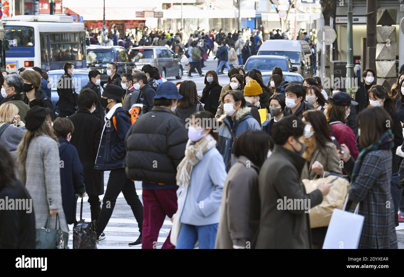 People wearing face masks walk in Tokyo's Shibuya area on Dec. 28, 2020 ...